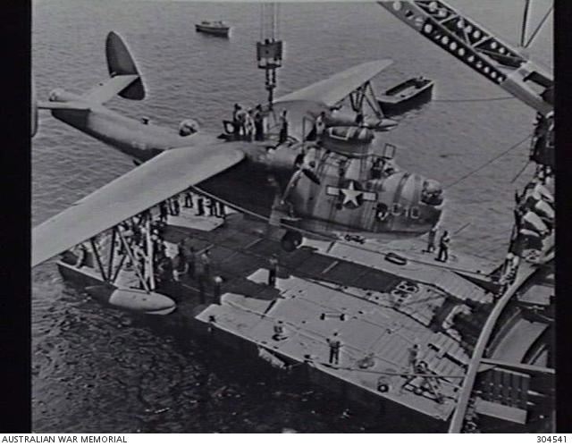 1945. A MARTIN PBM MARINER PATROL BOMBER IS LOWERED ONTO A BARGE ...