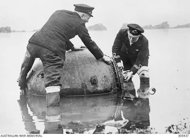 THE OFFICER OF A NAVAL MINE DISPOSAL PARTY REMOVES THE PRIMER FROM A ...