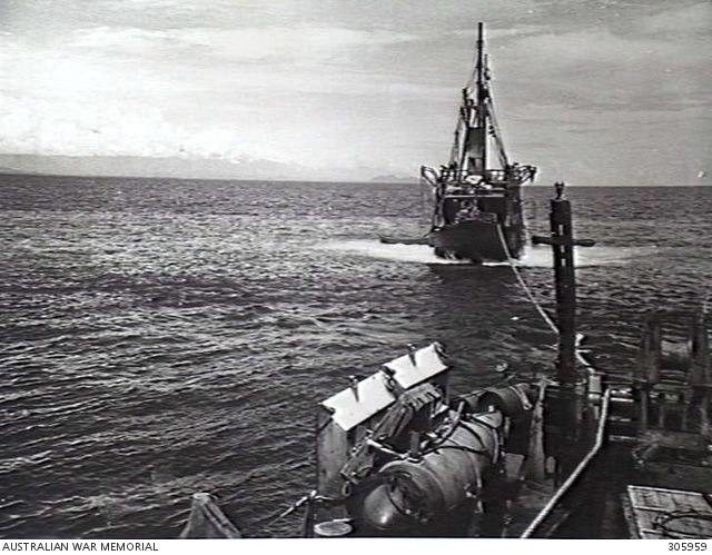 COLLINGWOOD BAY, NEW GUINEA. THE CORVETTE HMAS BROOME PREPARING TO TOW ...