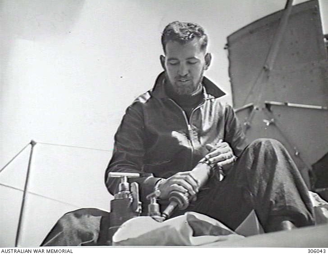 Able Seaman Reginald Thomas Sharpe (35514) of Macpherson St, Coolgardie, WA, greases the torpedo ...