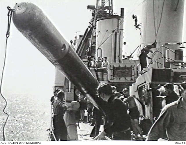 KOREA. C.1951. A PRACTICE TORPEDO IS RETRIEVED AND HOISTED ON BOARD ...