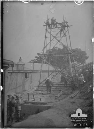 Engineers constructing a signal tower. A rope ladder is hanging from ...