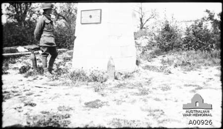 An Australian soldier standing next to a chalk monument which was ...