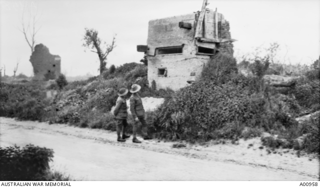 Two unidentified troopers inspecting the remains of a German concrete ...