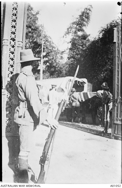 An Australian soldier standing guard as a coffin draped with a flag is ...