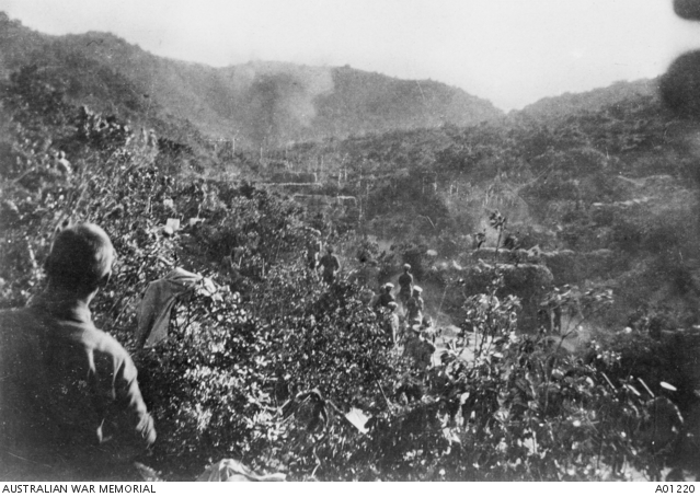 Soldiers watching as an 8 inch shell bursts in Monash Gully ...