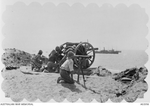 Gun crew in action using an 18 pounder Mk 1 Field Gun, aimed out to sea ...