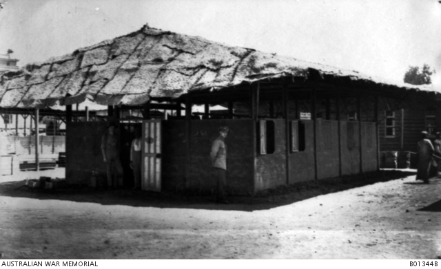 View of army huts being built of timber, wire netting, and matting. The ...