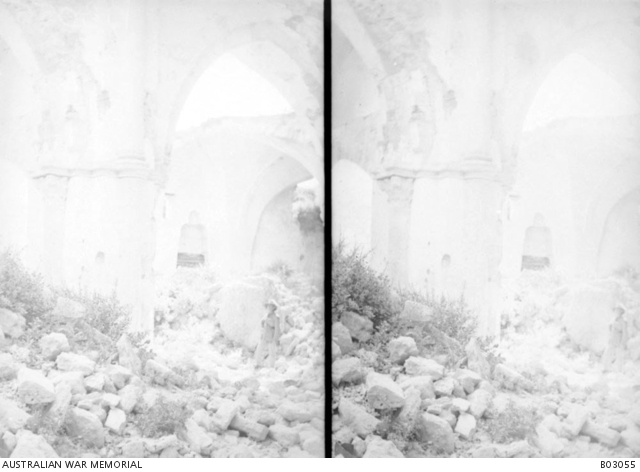 Interior view of a damaged mosque. A soldier (right) is standing among ...