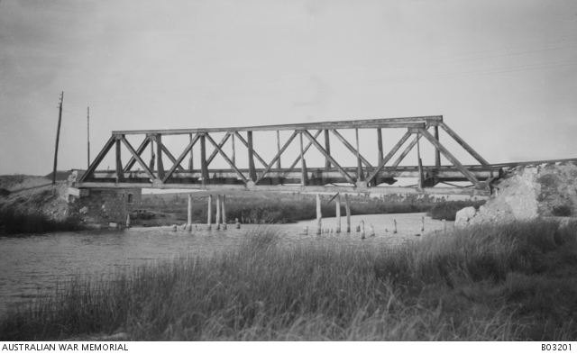 Remains of a damaged railway bridge. | Australian War Memorial