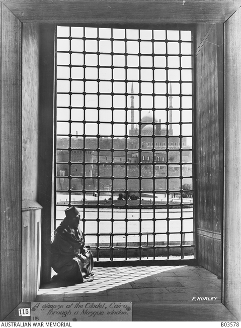 A glimpse of the Citadel, through a mosque window, a local man wearing ...