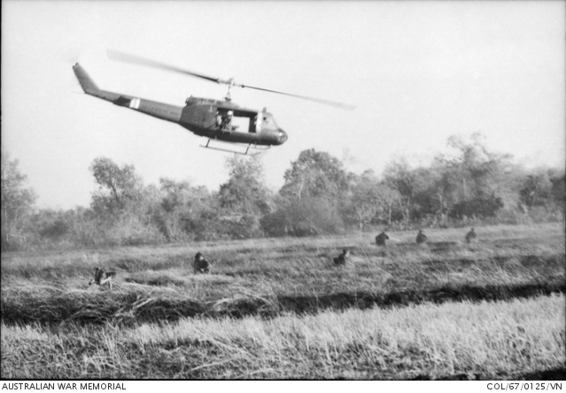 Vietnam. 1967. A helicopter returning for cover in open rice paddy ...