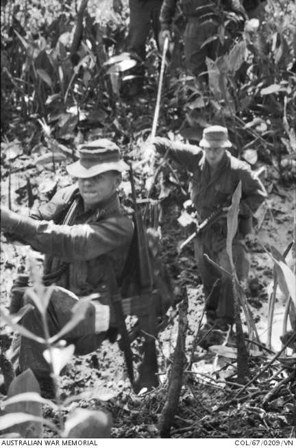 Vietnam. 1967. Struggling through mud in a mangrove swamp during Operation Portsea is Lance ...