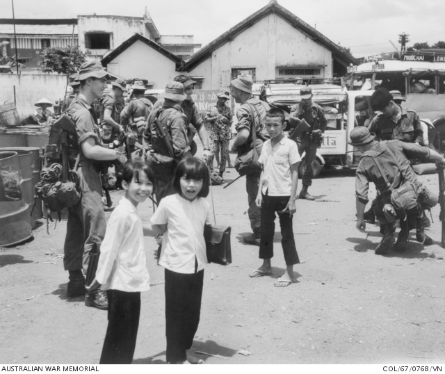 Vietnamese children smile, while soldiers of 7th Battalion, The Royal ...