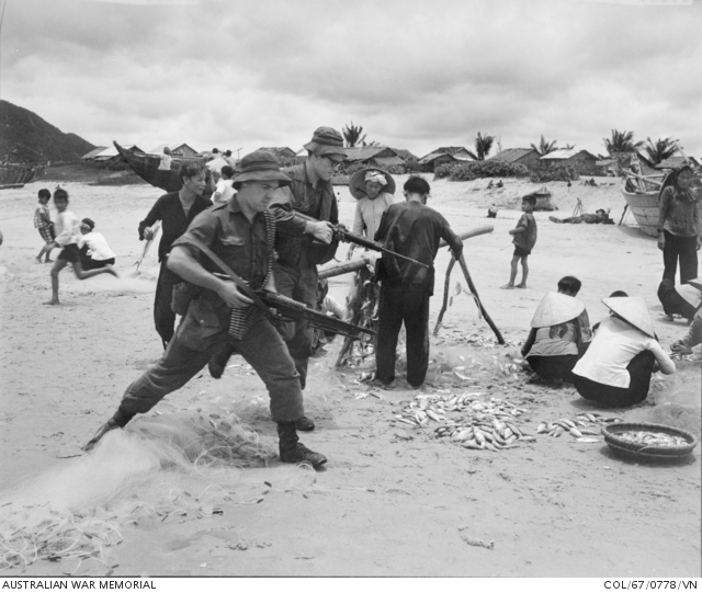 Vietnamese fishing folk go about their daily tasks on the beach while ...