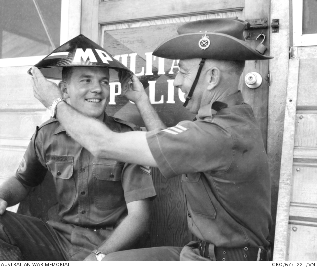 Seated in front of a Military Police sign, are Sergeant Bob Popperwell ...