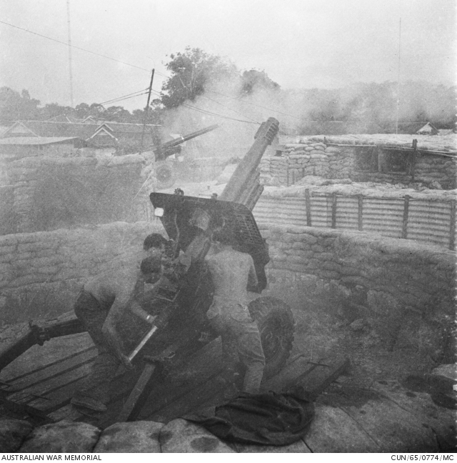 In the half light of dawn, an Australian artillery crew manning a 105mm ...