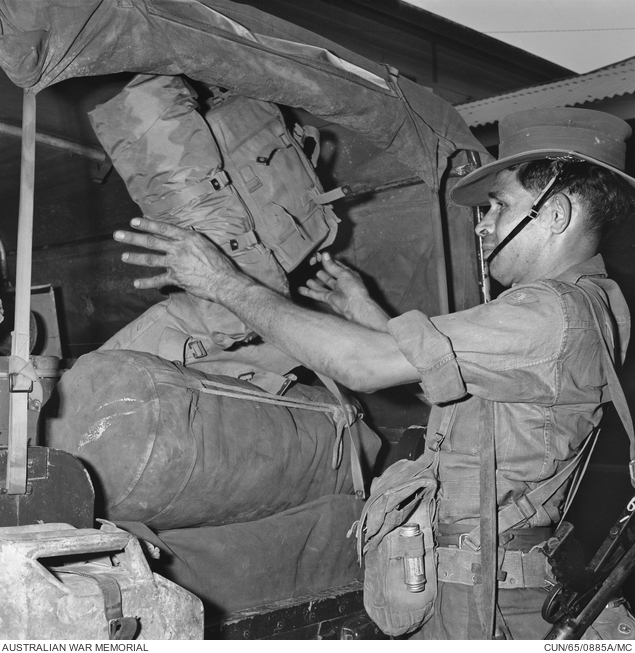 Stowing his gear aboard a Land Rover is 37726 Gunner (Gnr) (later ...
