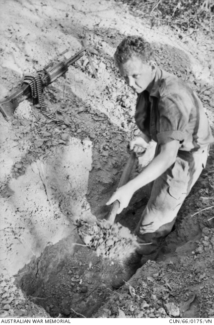 Private (Pte) Mick Waldron of Yagoona, Sydney, NSW, digs a fighting pit ...