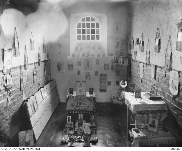 A view of a cell in the AIF Detention Barracks, with wall hangings and ...