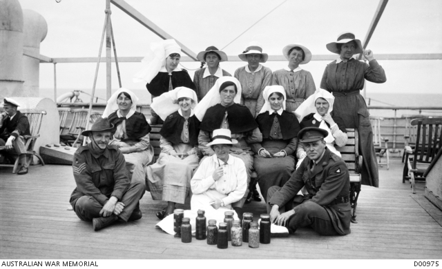 Group portrait of unidentified nurses and a lieutenant on board HMAT ...