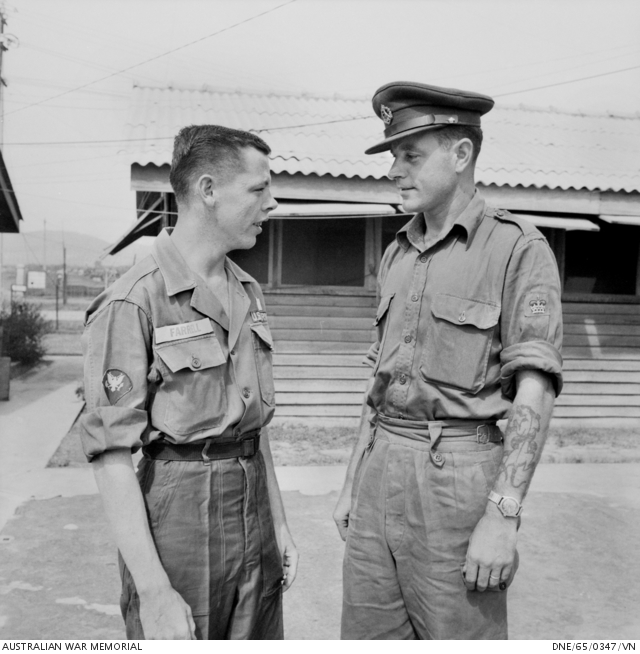 Specialist Edward Farrell (left) of New York, USA, talks with ...