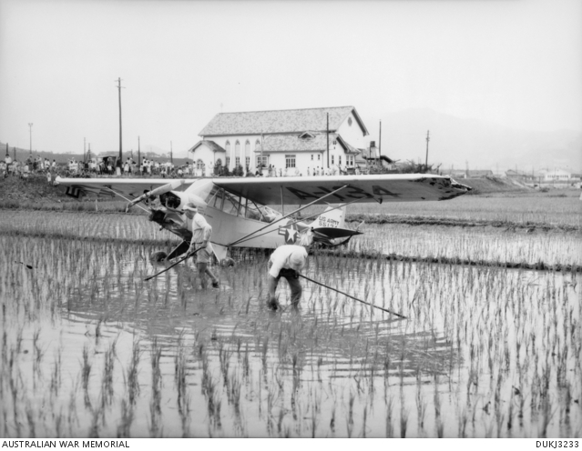 A US Army aircraft (A-134, 55134) has landed in a rice paddy, in a ...