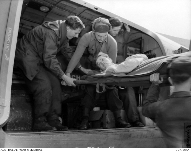 A wounded stretcher case being loaded onto a C47 transport aircraft for ...