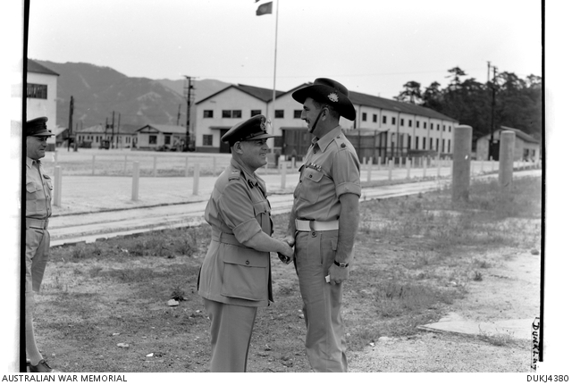 Major General F Kingsley Norris, CBE, DSO ED, shakes hands with an ...