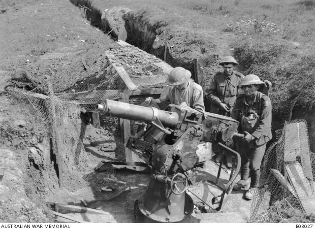 Three unidentified Australian soldiers take a look at a one pounder ...