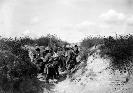 Escorting the wounded and prisoners along a trench, still under machine ...