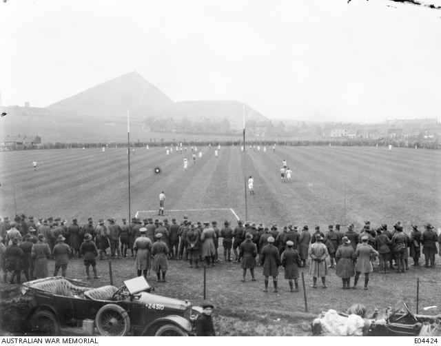 A group of Australian soldiers watching an Australian Rules football ...