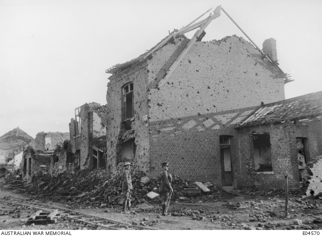 Two Australian officers standing outside the extensively shell damaged ...