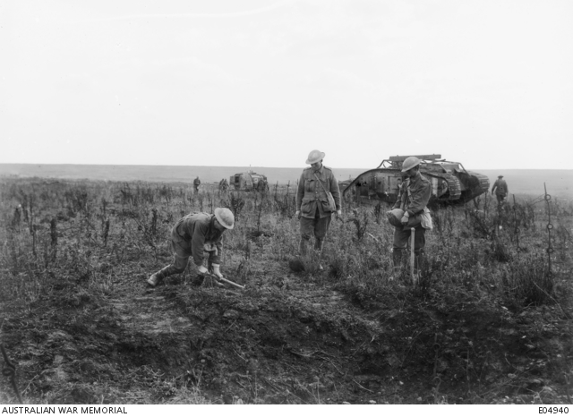 Three unidentified Australian soldiers digging out land mines amidst ...