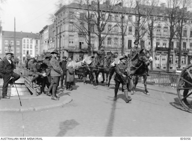 A group of Australian soldiers and civilians gathered on the side of a ...
