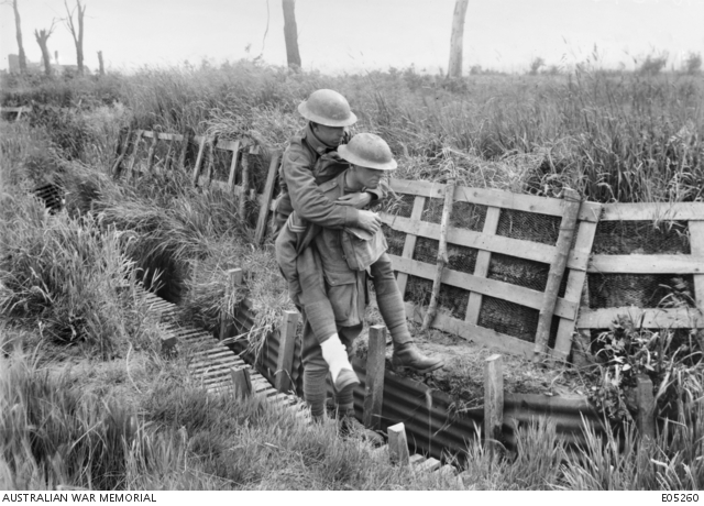 An unidentified soldier carrying on his back a wounded member of the ...