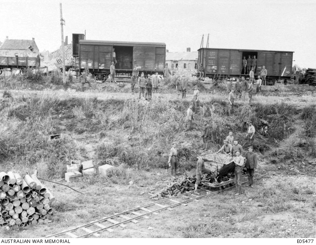 A large group of German prisoners loading empty shell cases on to ...