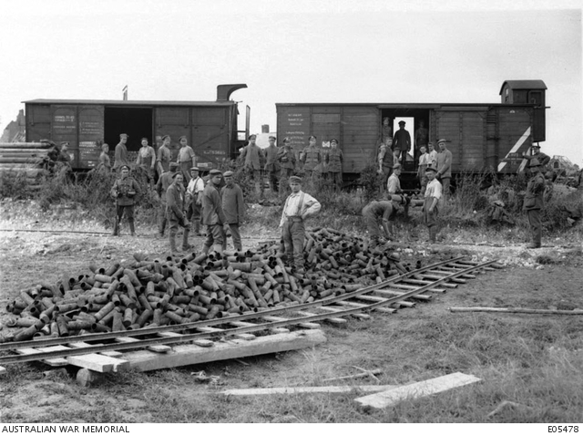 A large group of German prisoners loading empty shell cases on to ...