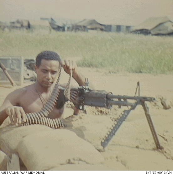 South Vietnam. 1967. Digger examining the ammunition belt of a 7.62mm GPMG M60 machine gun ...