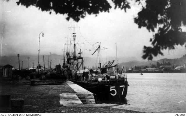 The destroyer HMAS Torrens alongside an oil wharf. The objects piled up ...