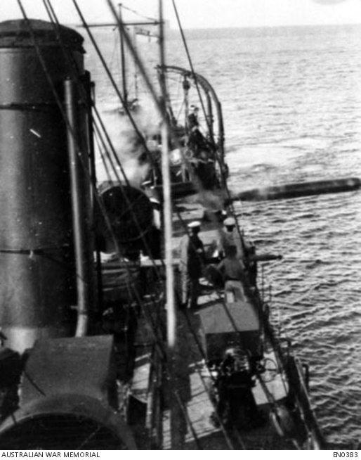 A torpedo being fired from the destroyer HMAS Huon. With HMAS Swan and ...
