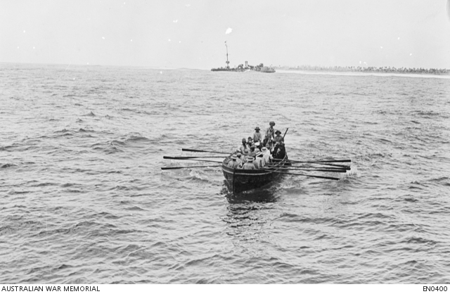 A boat returns to HMAS Sydney after boarding the German raider Emden on ...