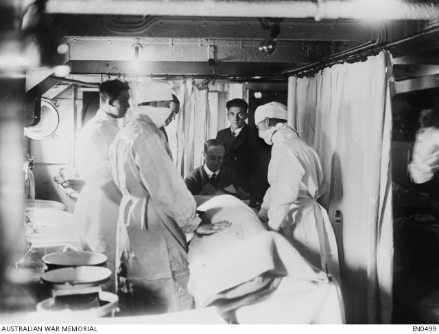 Medical officers perform an operation in the sick bay aboard HMAS ...