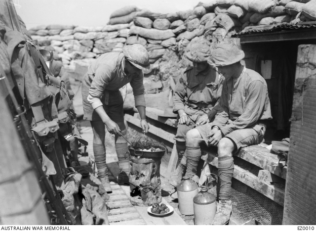 An unidentified Australian soldier cooks a piece of meat for dinner in ...