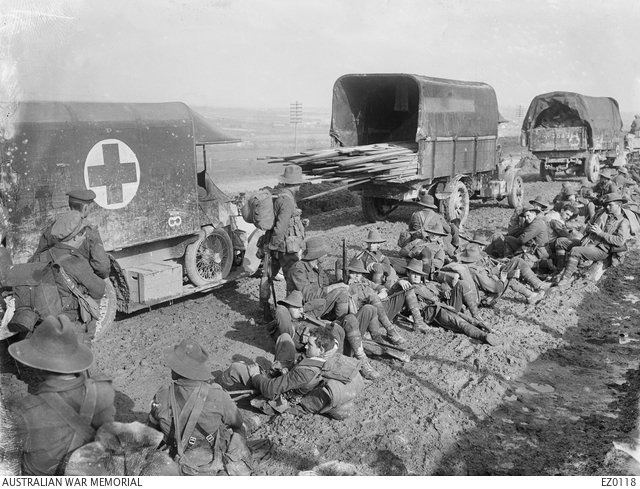 Infantry of the 2nd Australian Division rest while they halt on a muddy ...