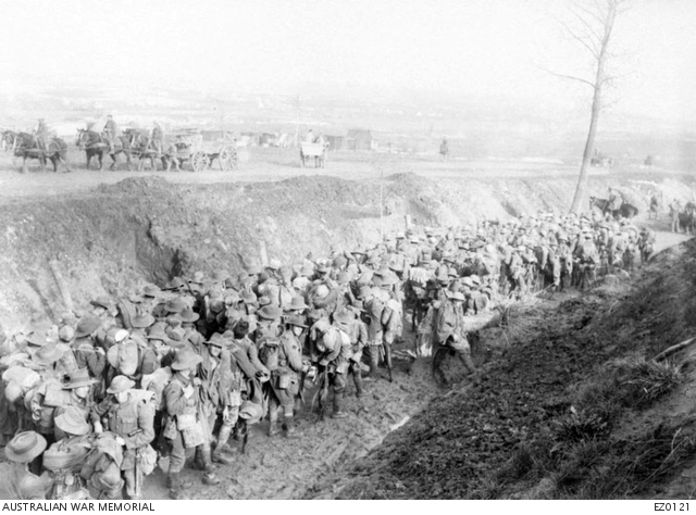 Members of the 2nd Australian Division halted on a muddy sunken road ...