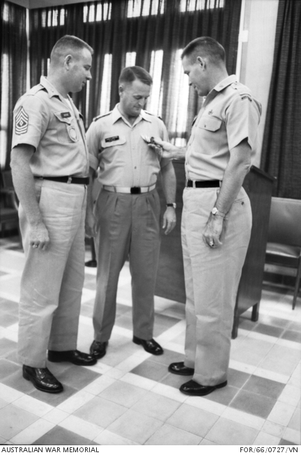Two American soldiers inspect the Vietnamese Service Medal worn by ...