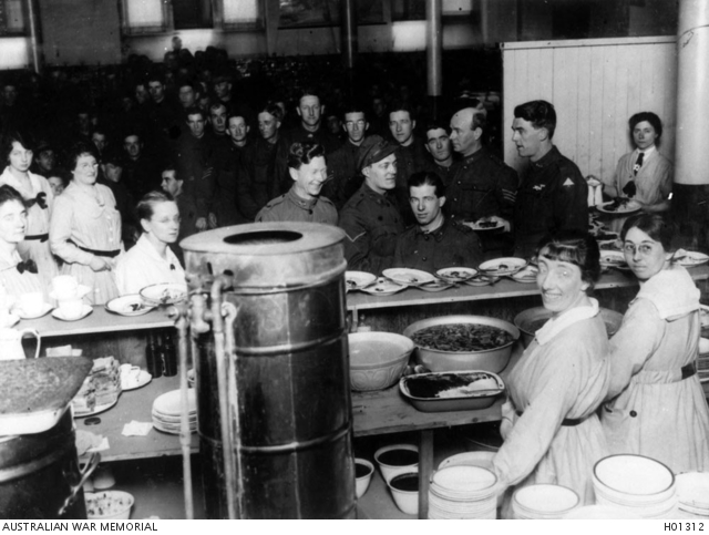 LONDON, ENGLAND. 1918. KITCHEN STAFF WITH SERVICE PERSONNEL CUSTOMERS ...