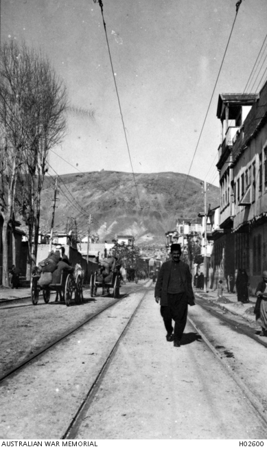 A STREET SCENE SHOWING ELECTRIC TRAM LINES, HORSES AND CARTS AND ...