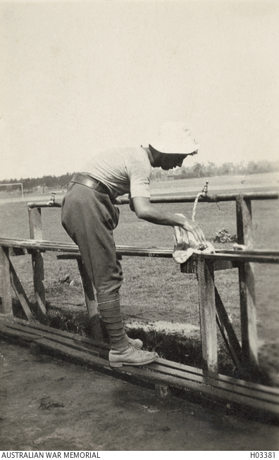 Soldier washing his clothes. | Australian War Memorial